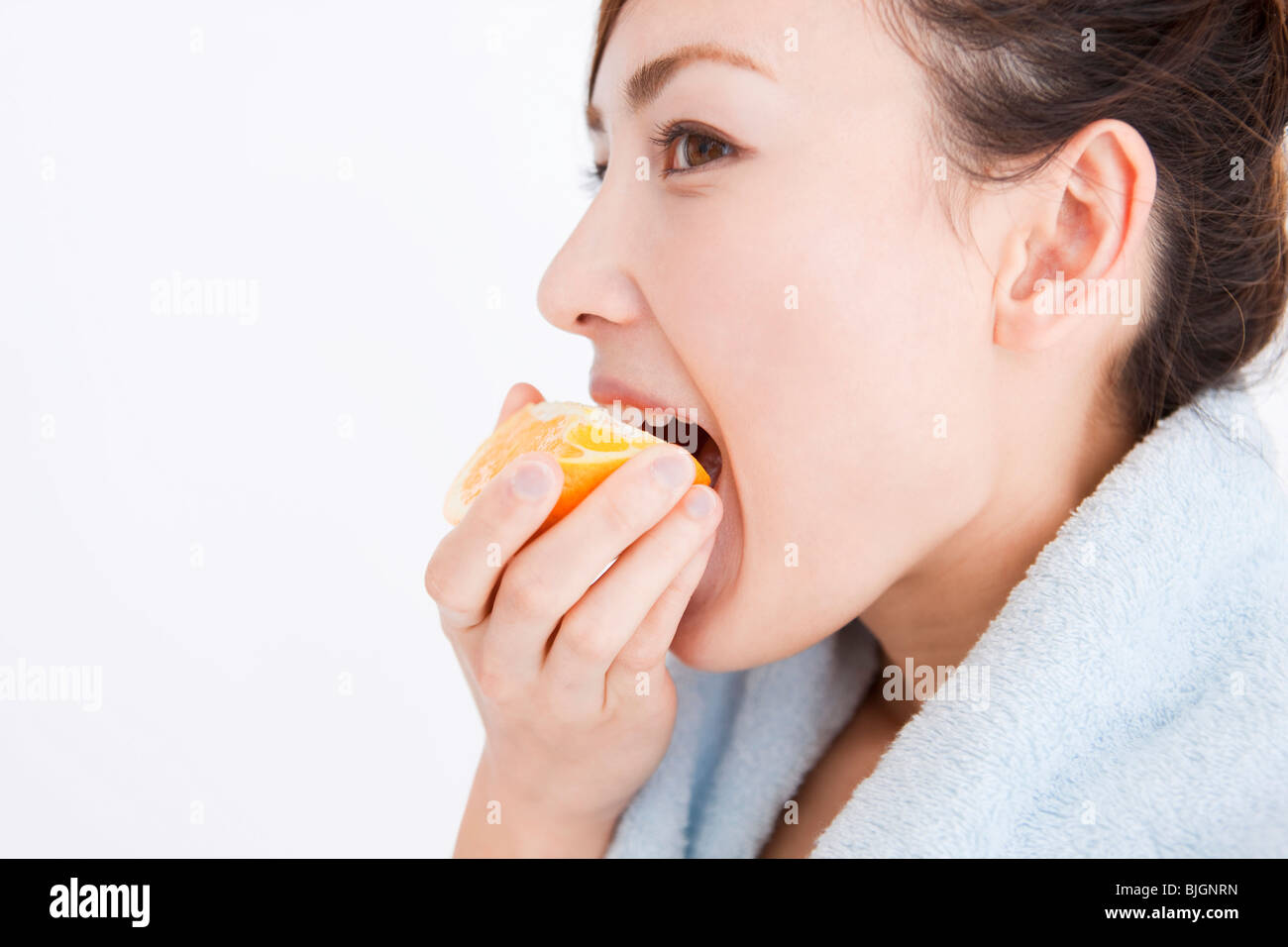 Woman eating an orange Stock Photo - Alamy