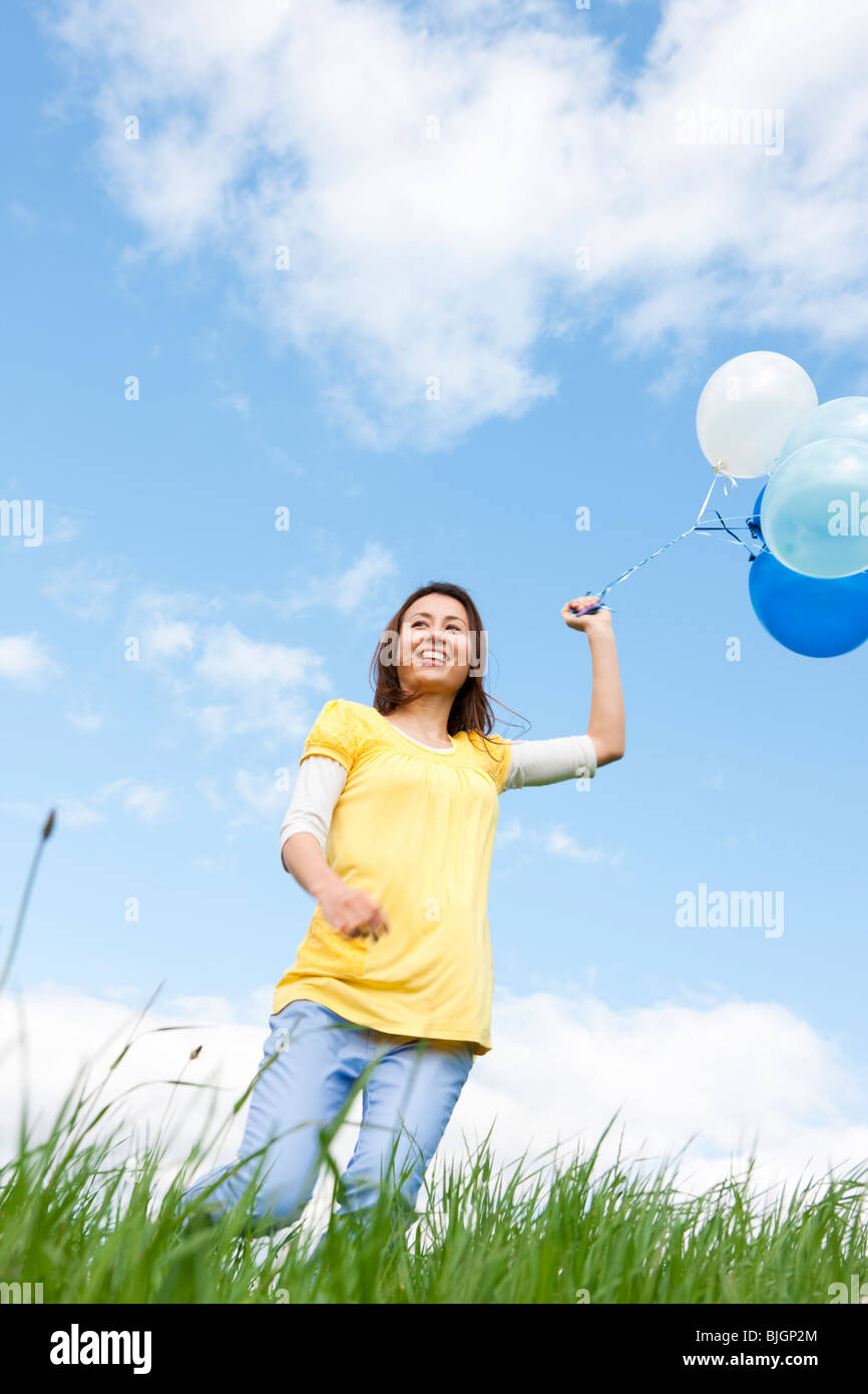 Woman running with balloons Stock Photo - Alamy
