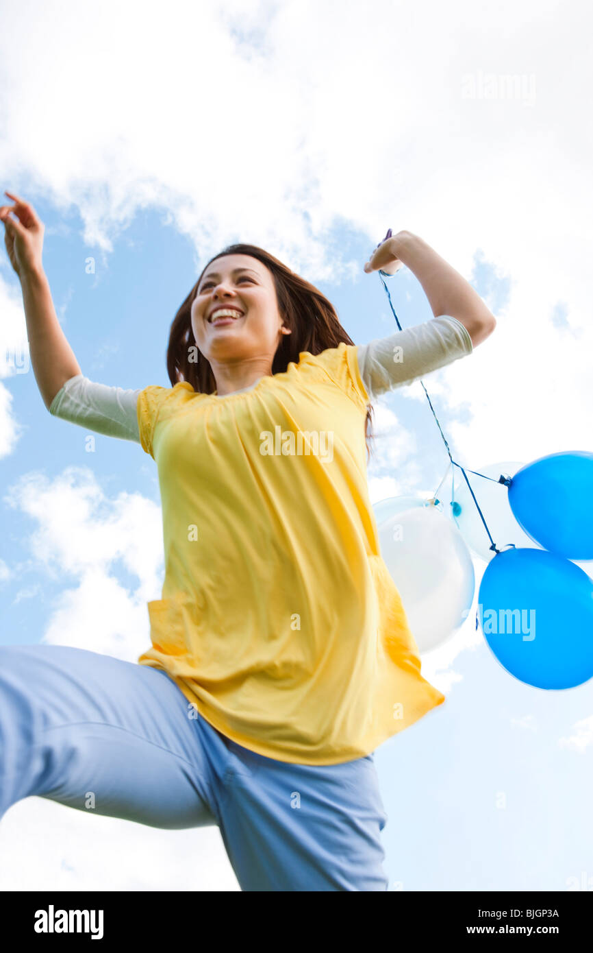 Woman running with balloons Stock Photo - Alamy