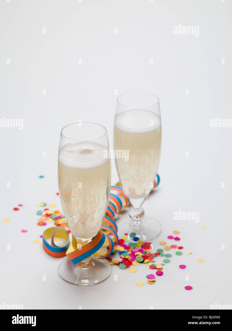 Two glasses of sparkling wine, paper streamer and confetti Stock Photo ...