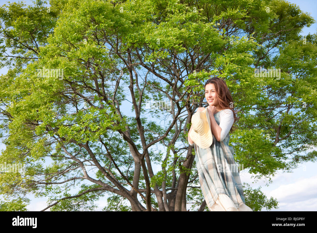 Woman standing next to a tree Stock Photo - Alamy