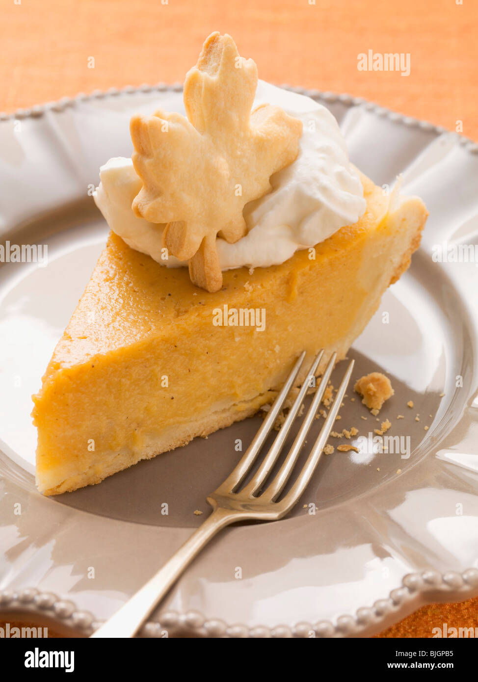 Piece of pumpkin pie with cream and pastry leaf Stock Photo - Alamy