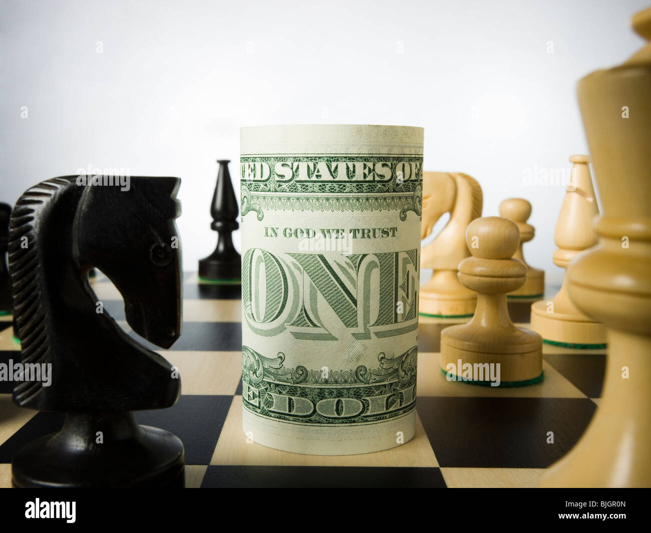 rolled currency on a chess board Stock Photo - Alamy