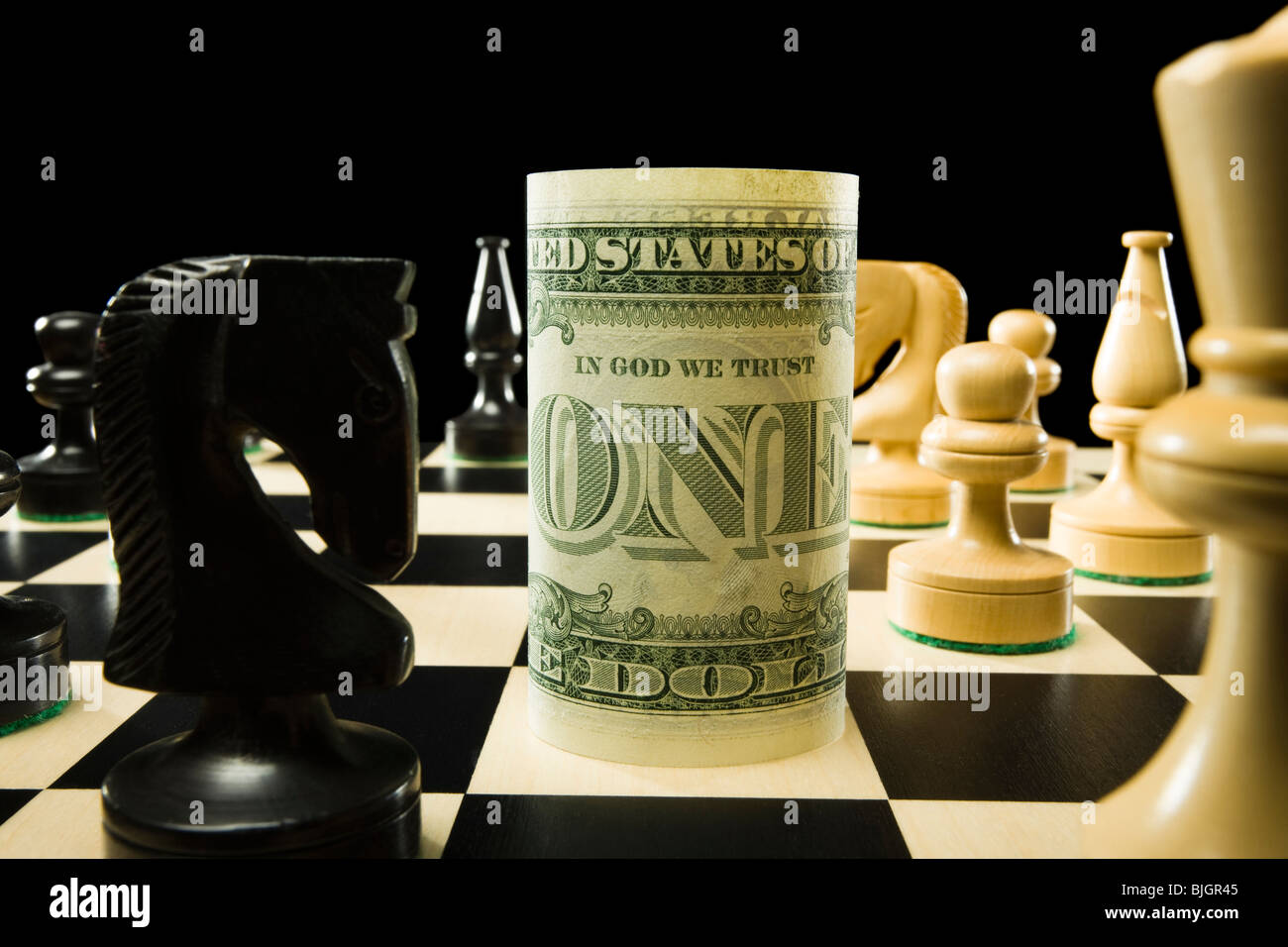 rolled currency on a chess board Stock Photo - Alamy