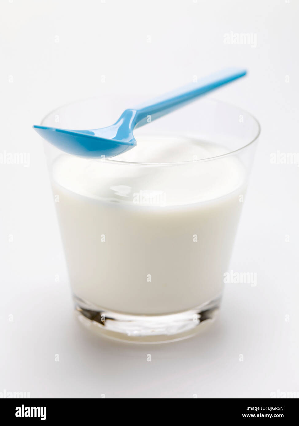 Natural yoghurt in glass with spoon Stock Photo - Alamy
