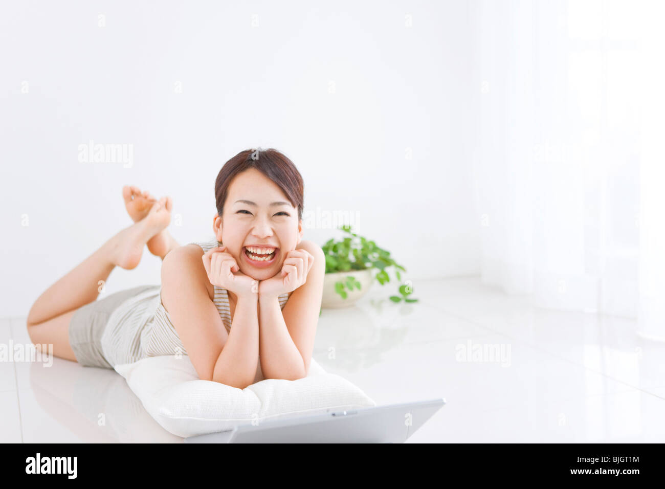Woman lying on floor with laptop computer Stock Photo - Alamy