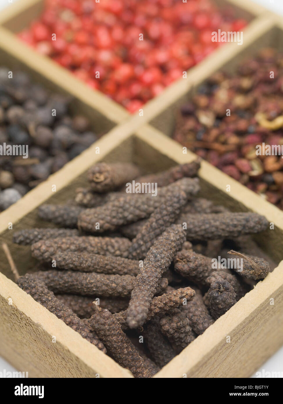 Spices and dried berries in wooden container Stock Photo - Alamy