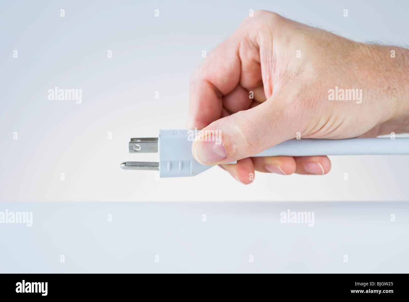Hand holding plug Stock Photo - Alamy