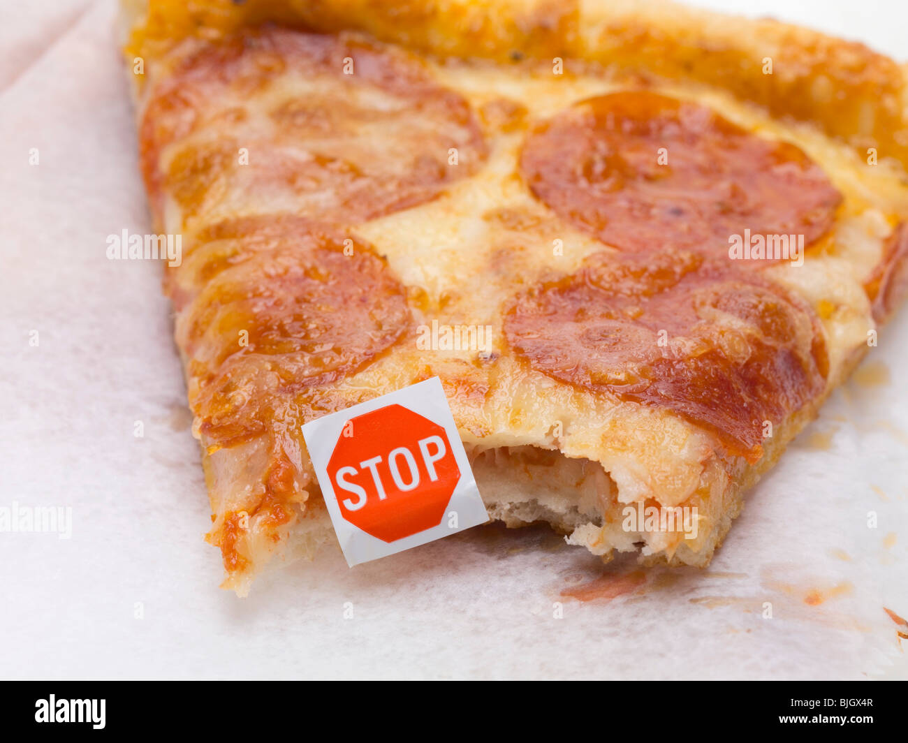 A slice of pizza with a 'Stop' sign Stock Photo - Alamy