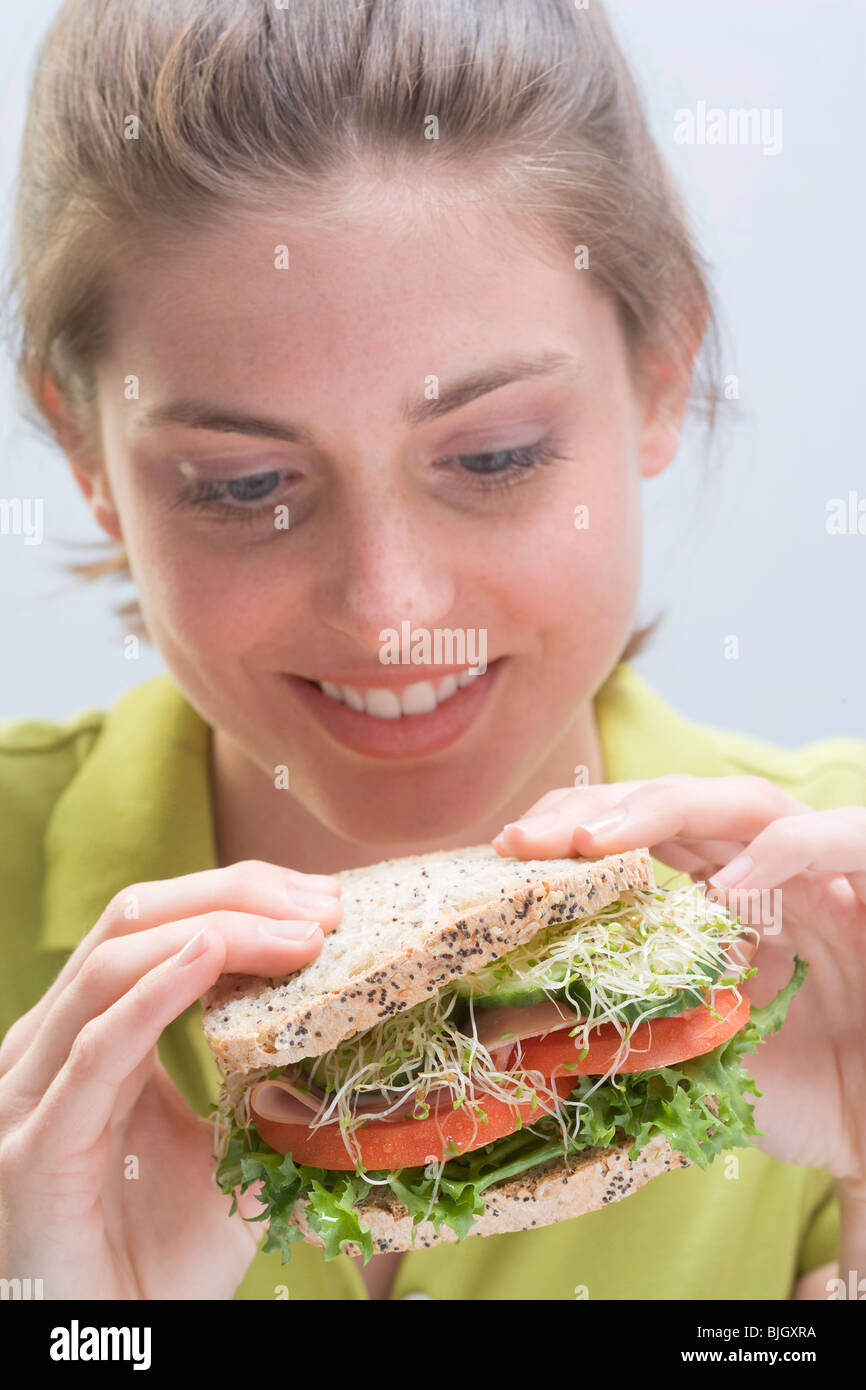 Young woman holding a sandwich Stock Photo - Alamy