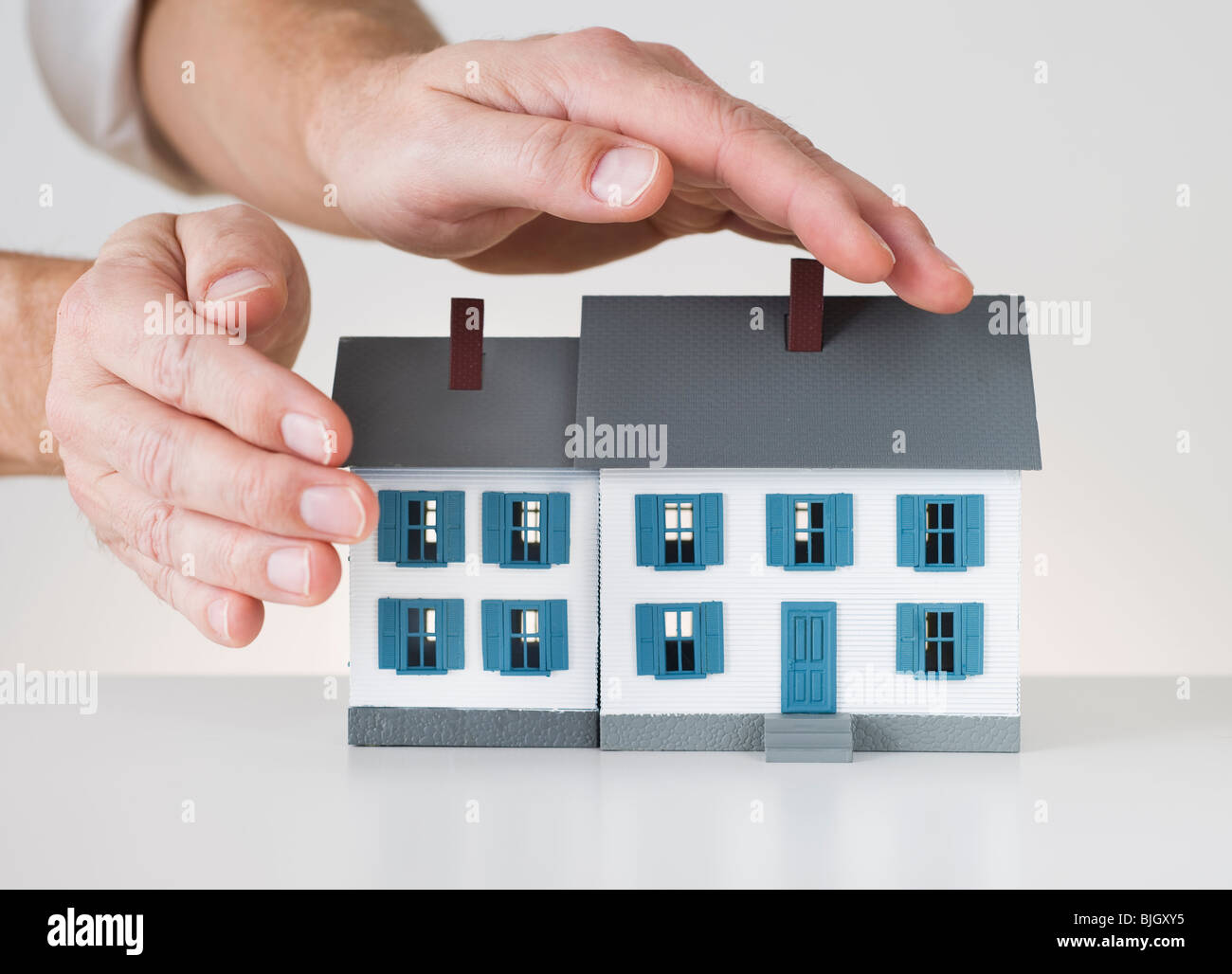 Hands touching toy house Stock Photo - Alamy