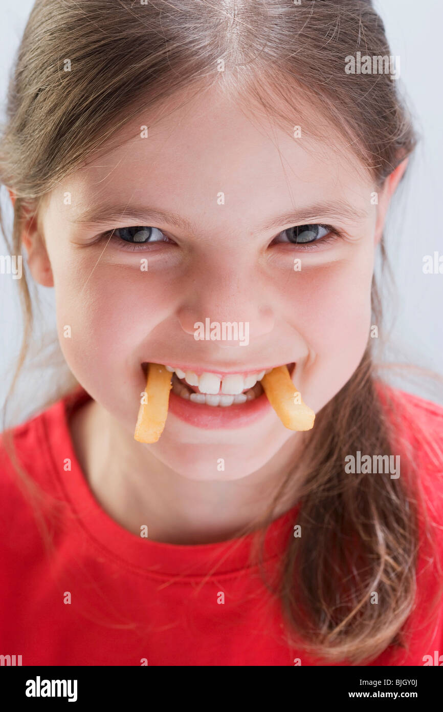 Mischievous girl with chip fangs Stock Photo - Alamy