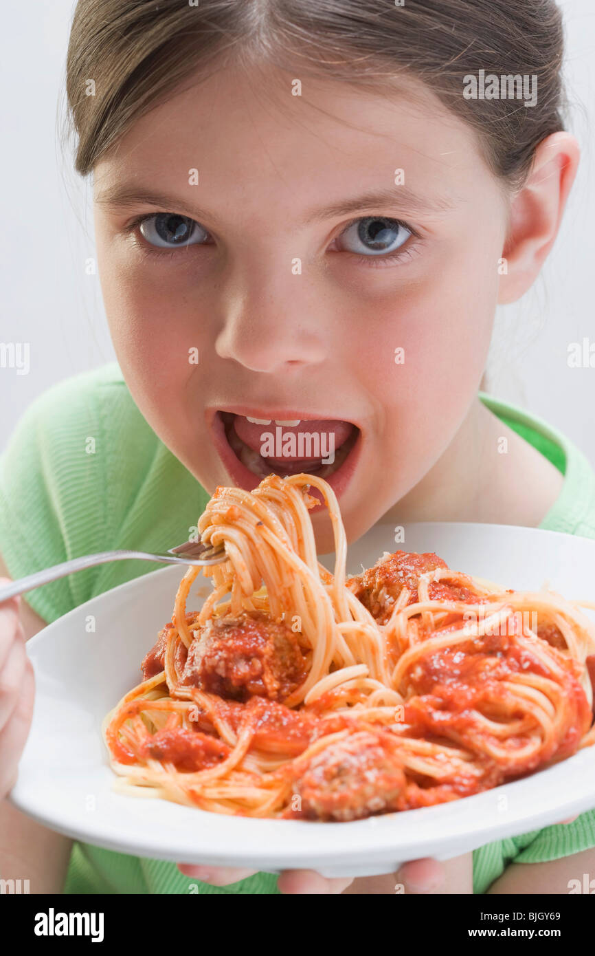 Girl eating spaghetti with meatballs Stock Photo - Alamy