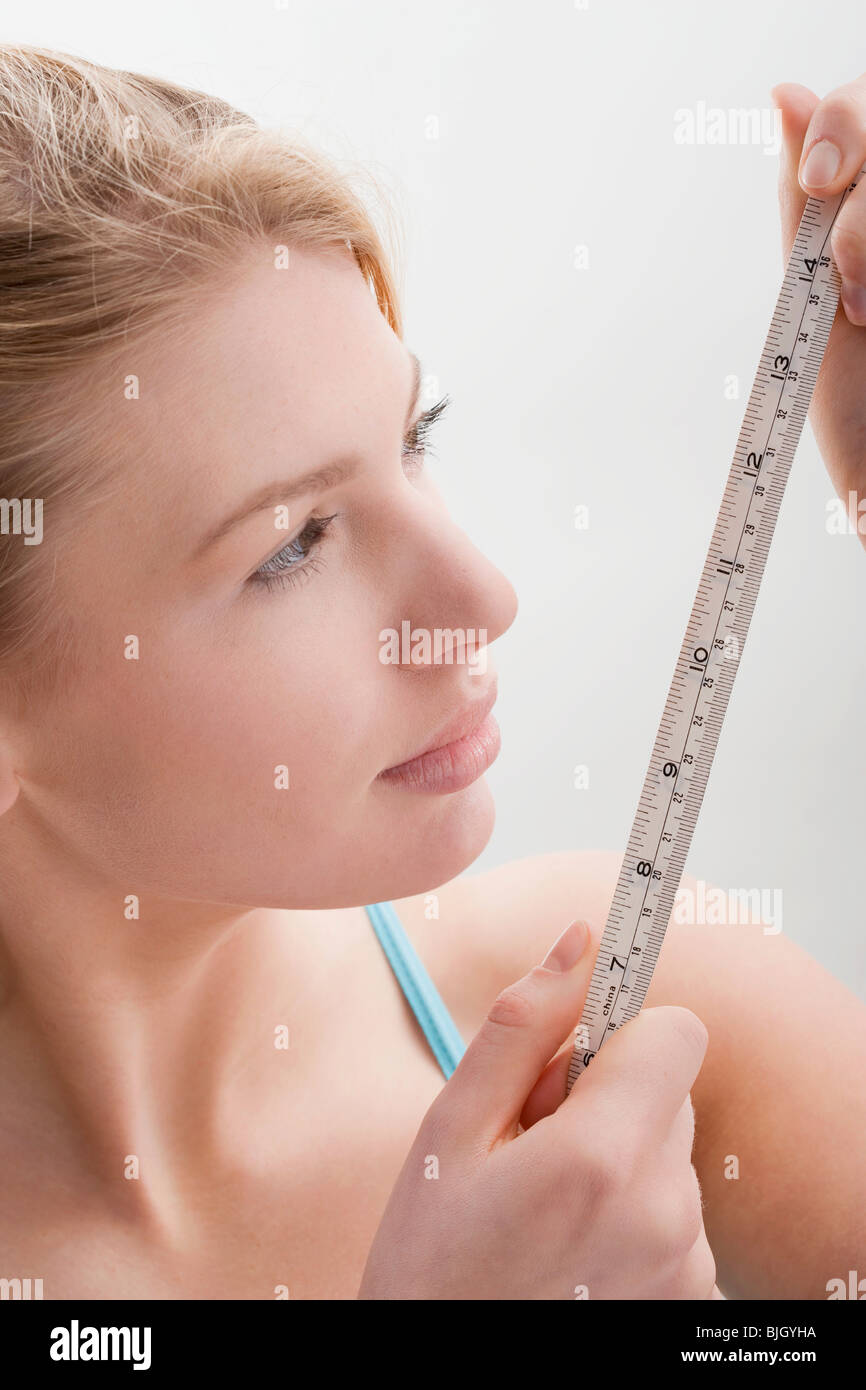 Thoughtful woman tape measure weight hi-res stock photography and ...