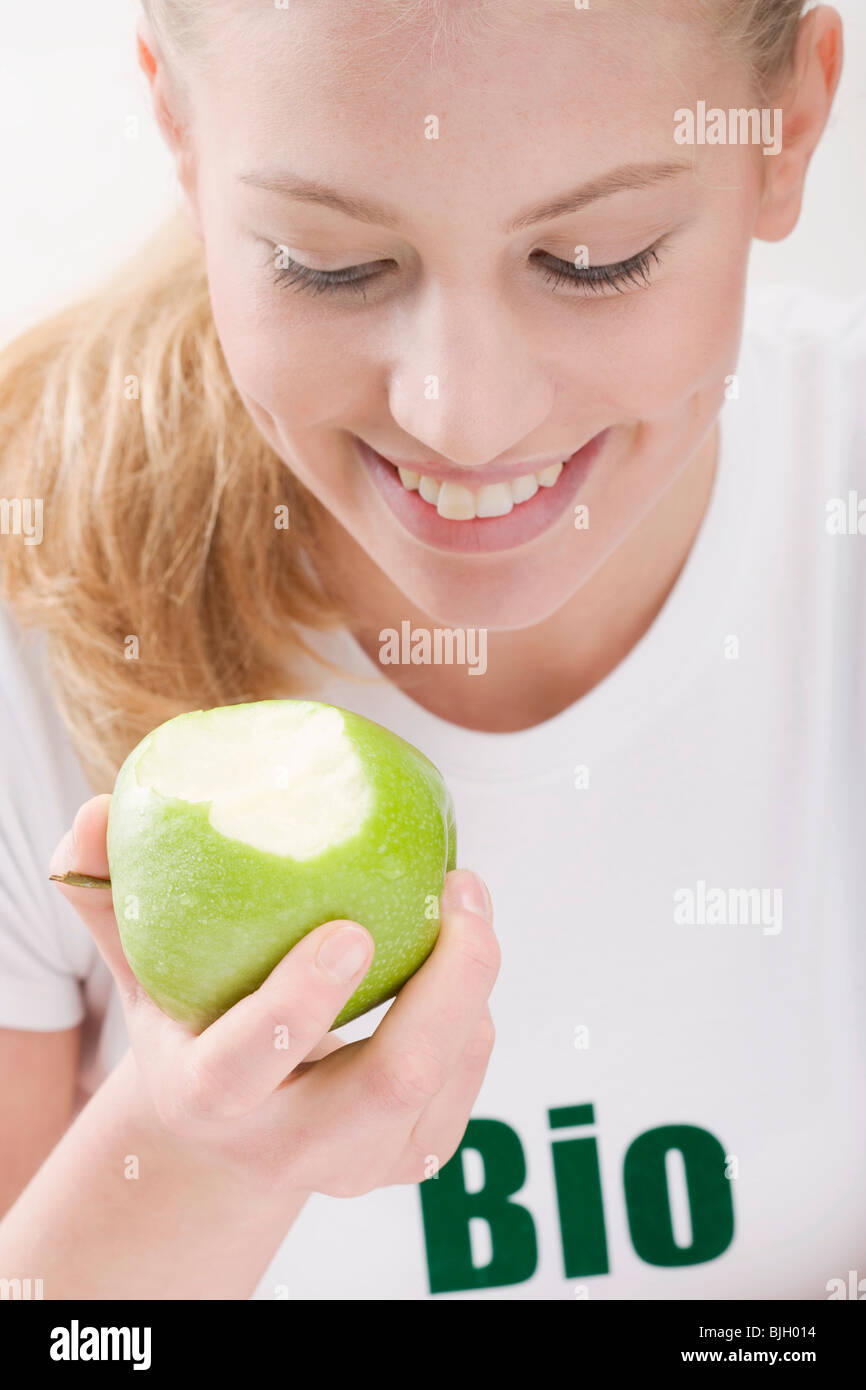 Woman eating an organic green apple Stock Photo - Alamy