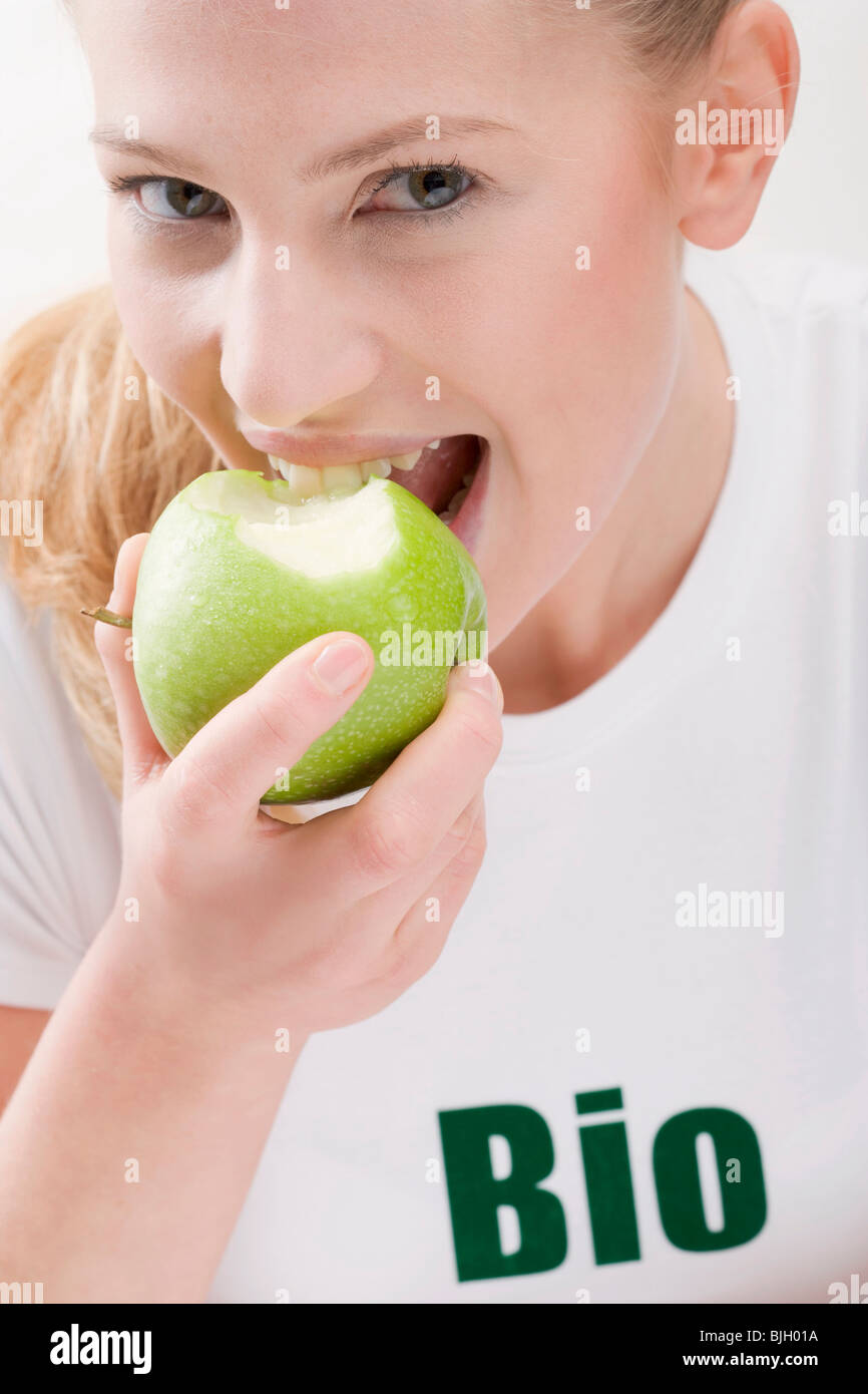 Woman eating organic green apple Stock Photo - Alamy