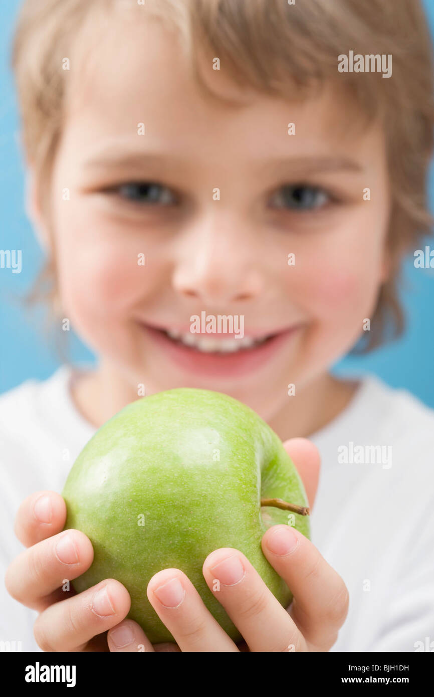 Little boy holding green apple Stock Photo - Alamy