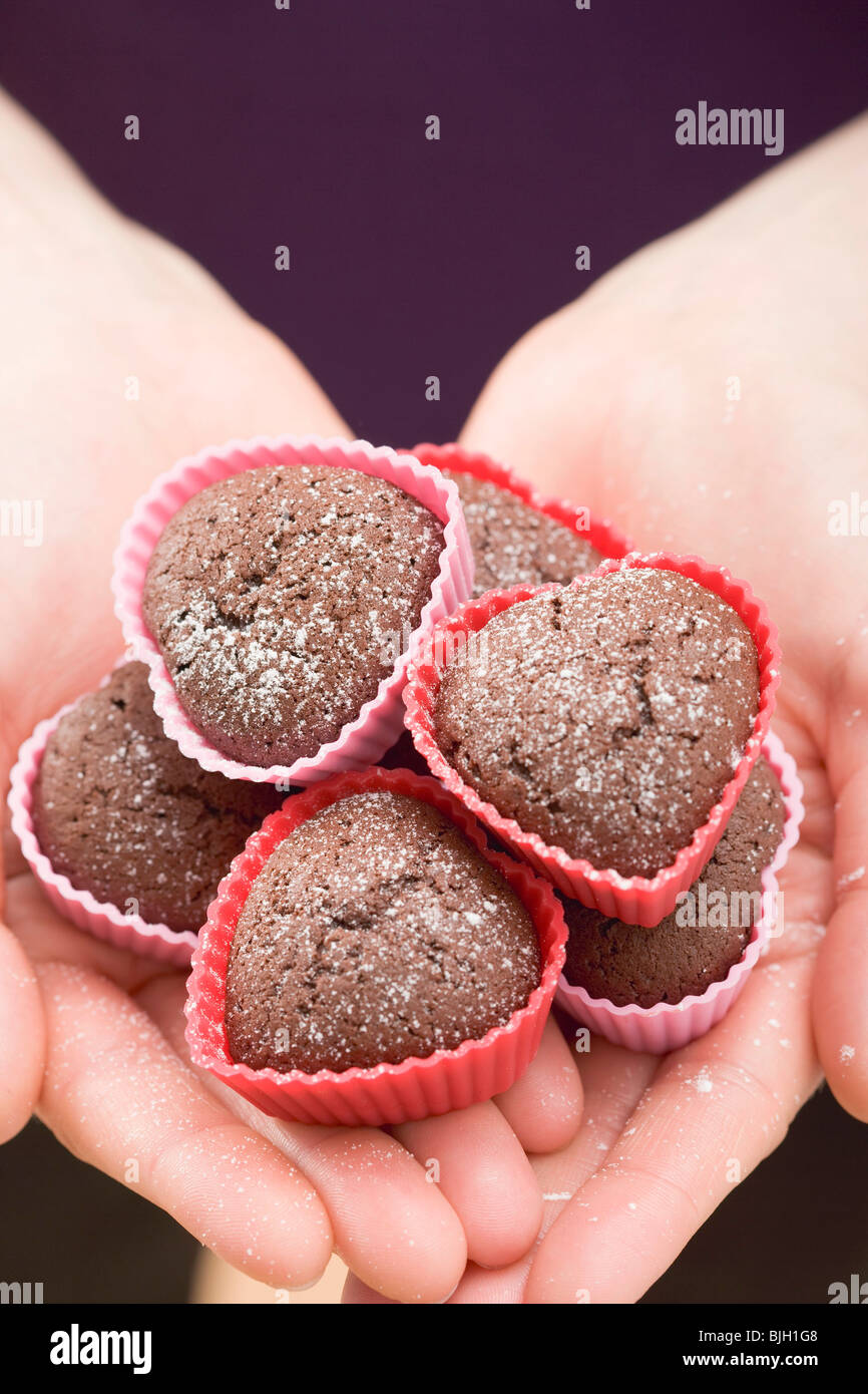 Woman holding heart-shaped chocolate buns Stock Photo - Alamy