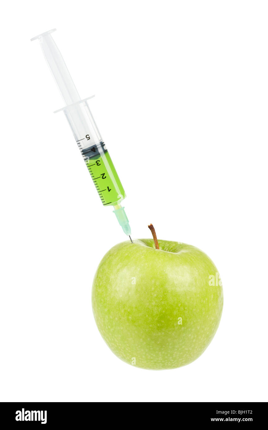 A green apple being injected with a syringe containing green fluid ...