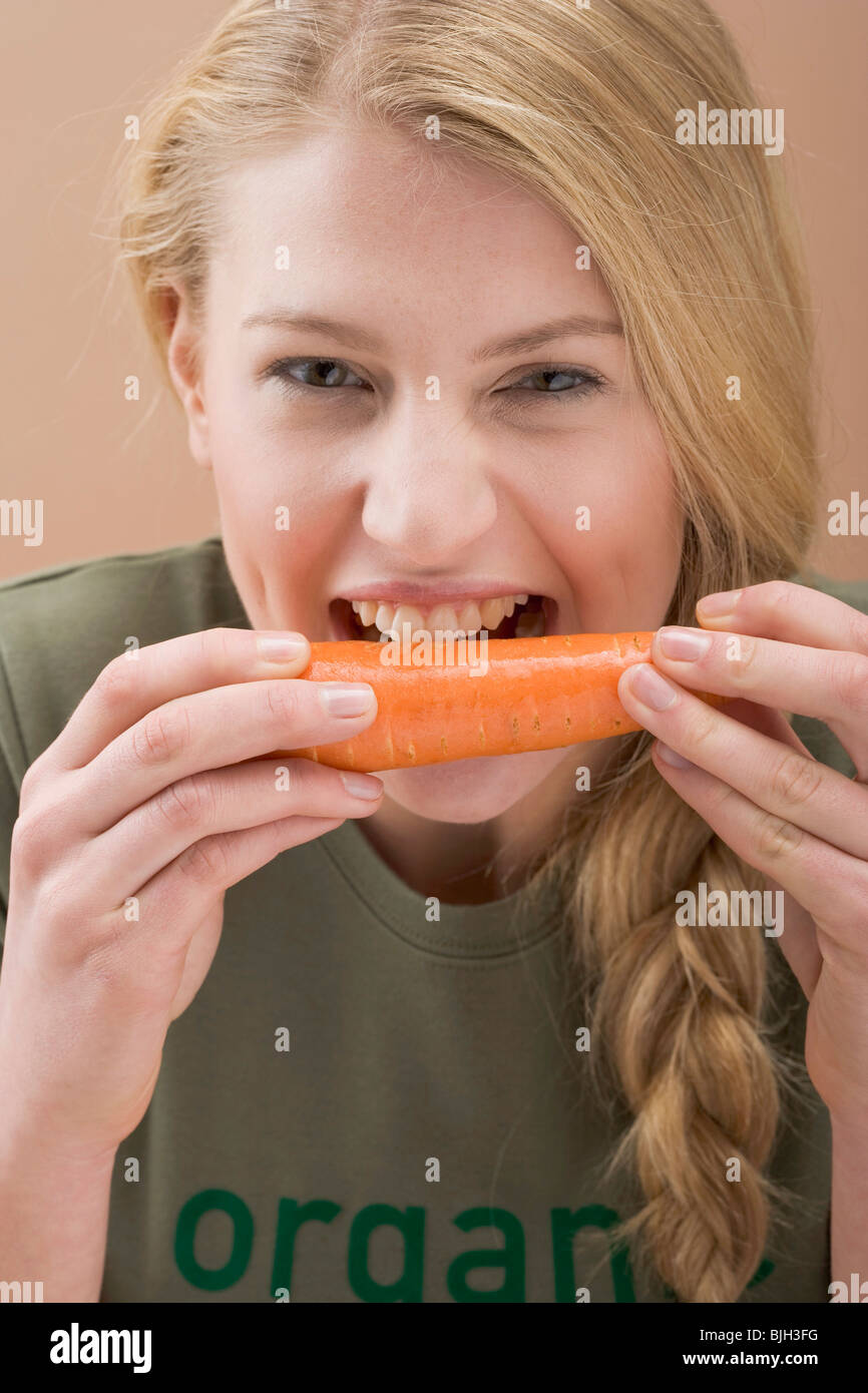 Woman biting a fresh carrot Stock Photo - Alamy
