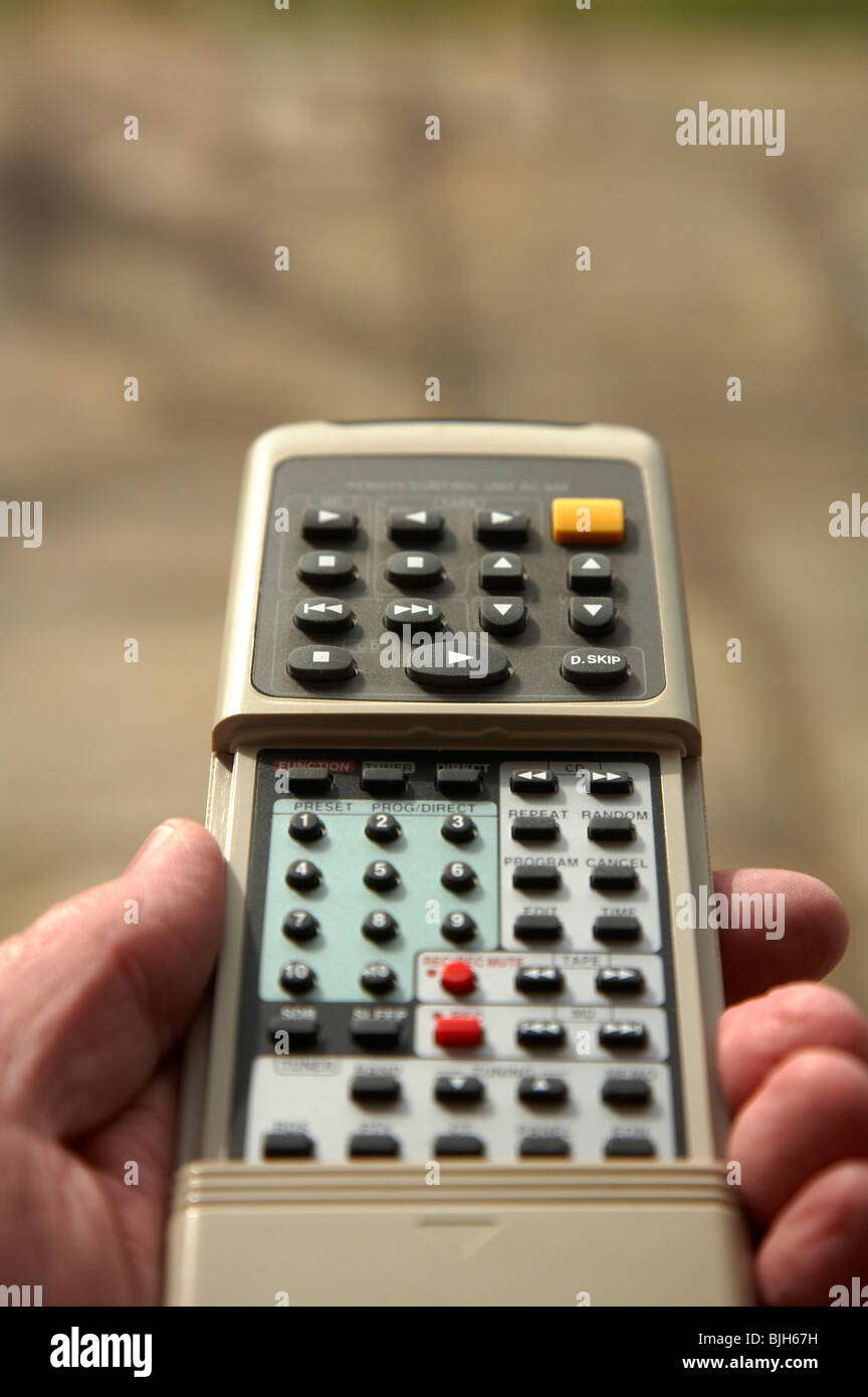 Hand holding remote control Stock Photo - Alamy