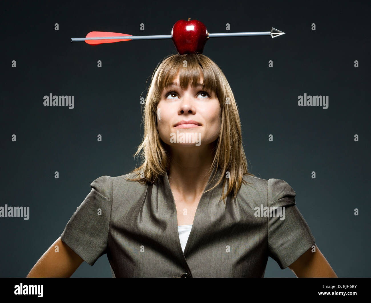 businesswoman with an apple with an arrow through it on her head Stock ...