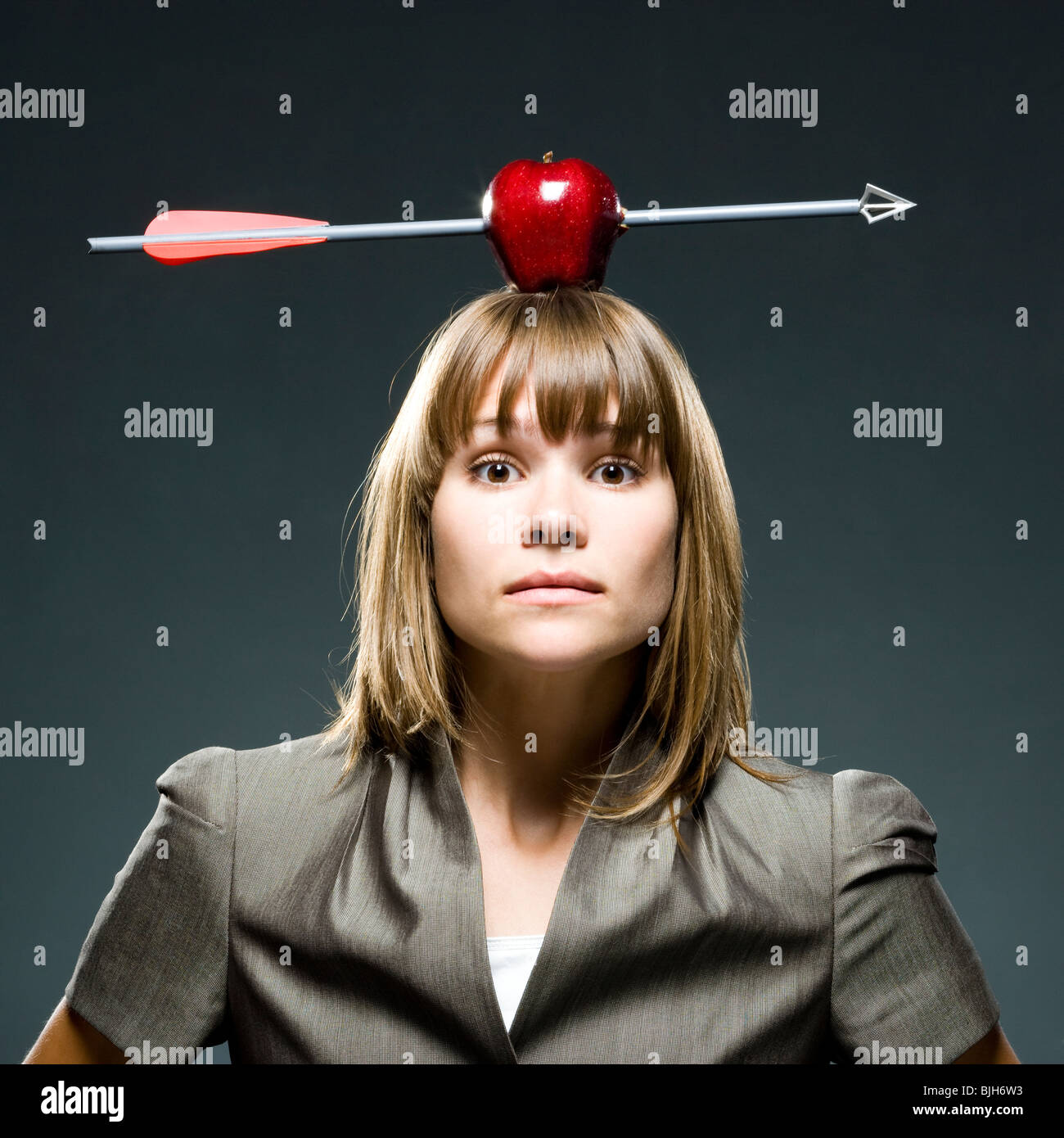 businesswoman with an apple with an arrow through it on her head Stock ...