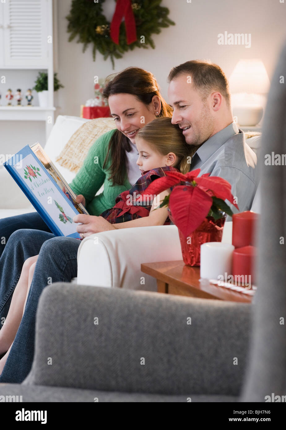 Parents reading to daughter Stock Photo - Alamy