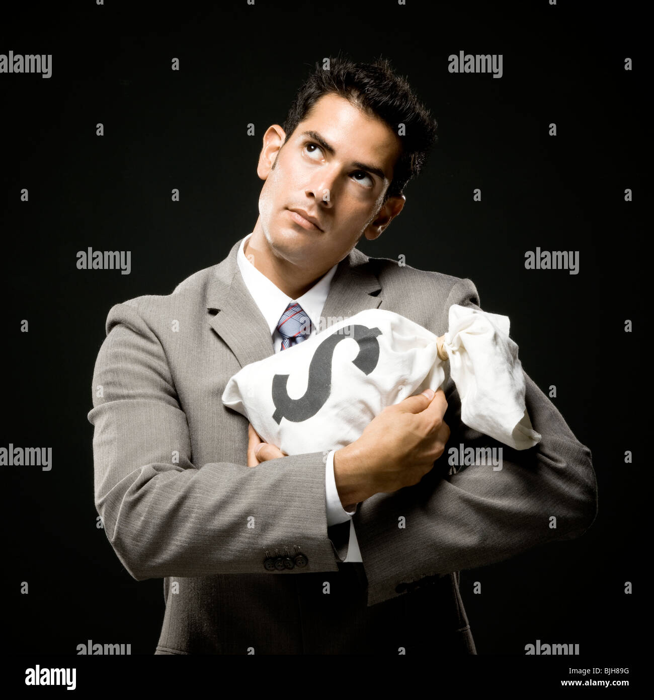 businessman holding a bag of money like a baby Stock Photo - Alamy