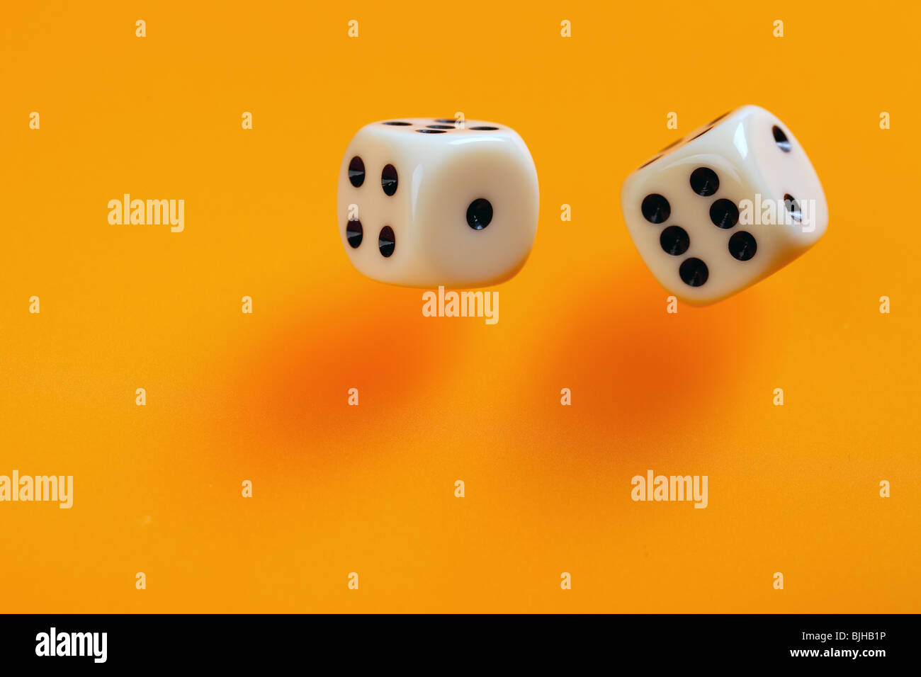 two dice on orange background Stock Photo - Alamy