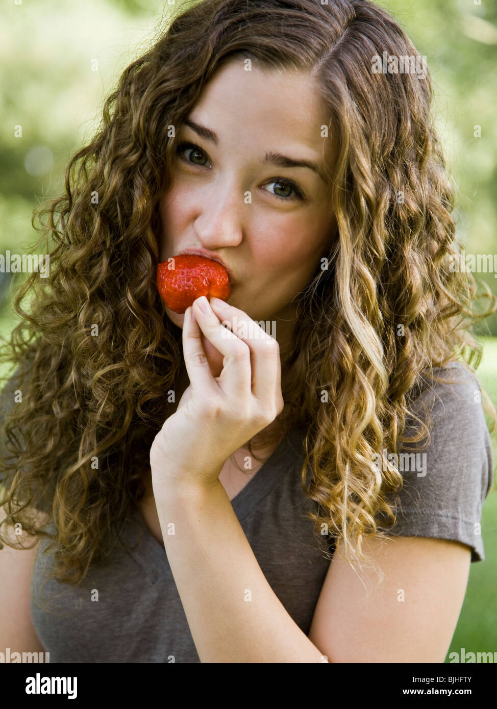 young woman eating a berry Stock Photo - Alamy