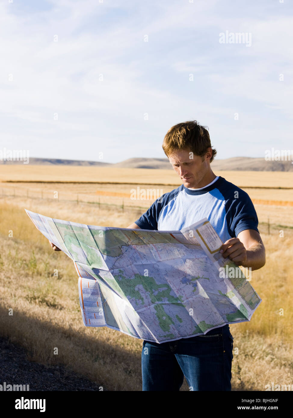 man looking at a map on the side of the road Stock Photo - Alamy