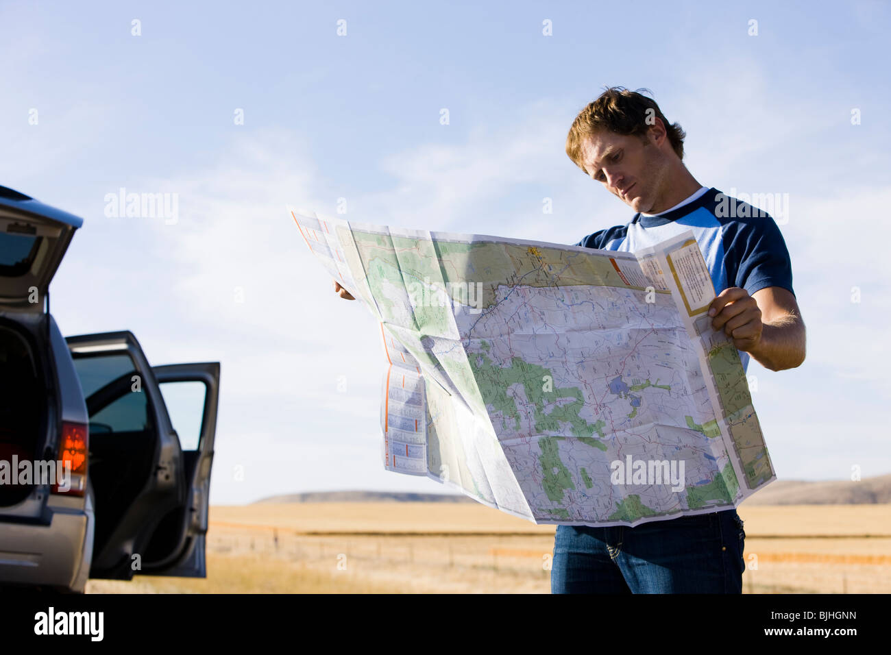 man looking at a map on the side of the road Stock Photo - Alamy