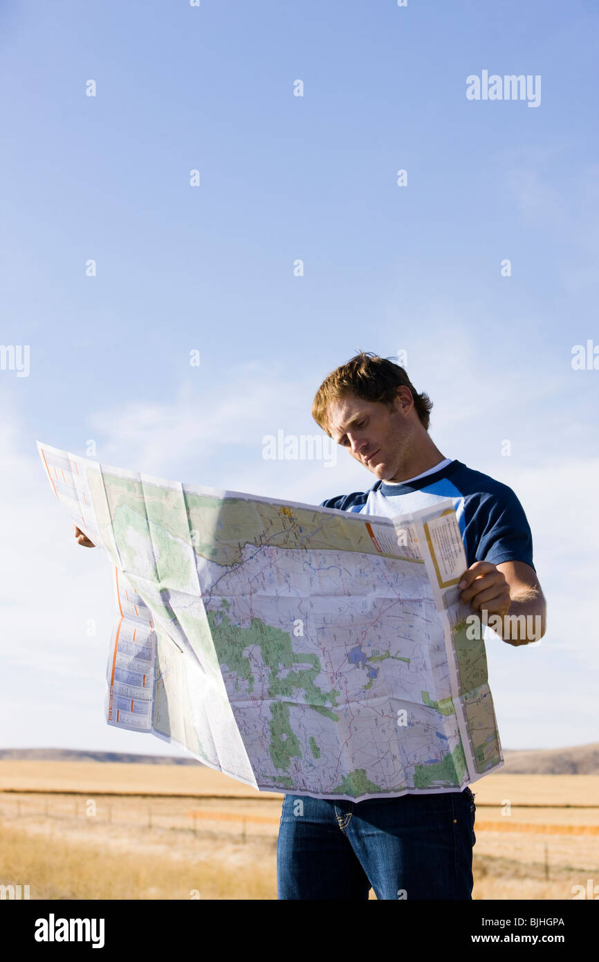man looking at a map on the side of the road Stock Photo - Alamy