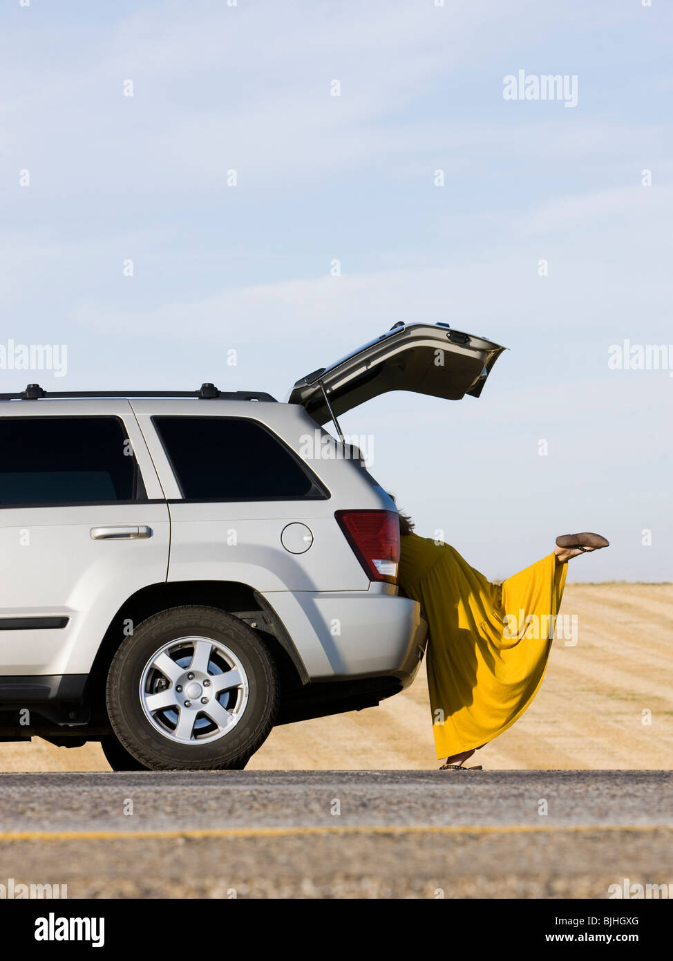 woman hanging out the back of her car on the side of the road Stock ...