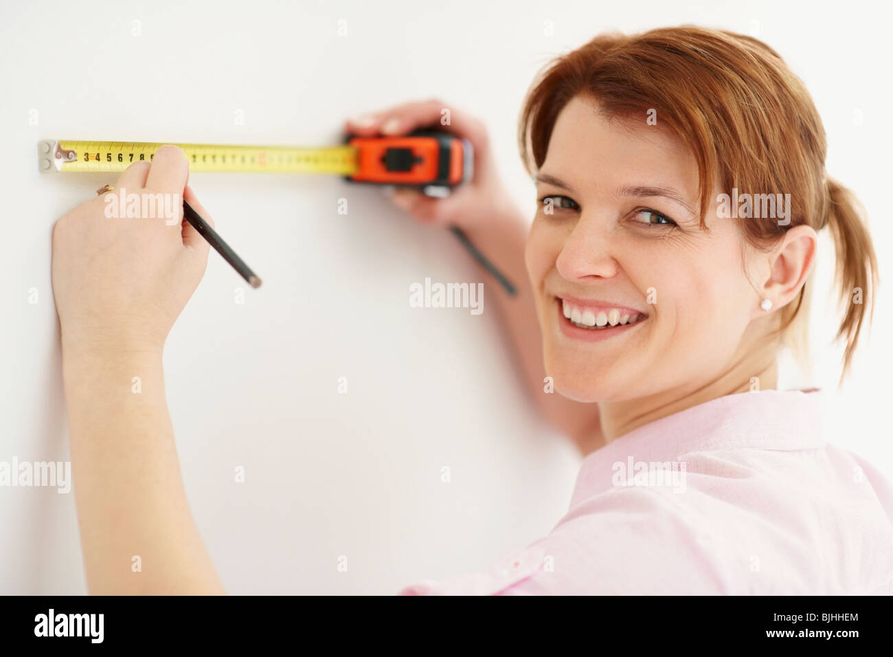Woman using measuring tape Stock Photo - Alamy