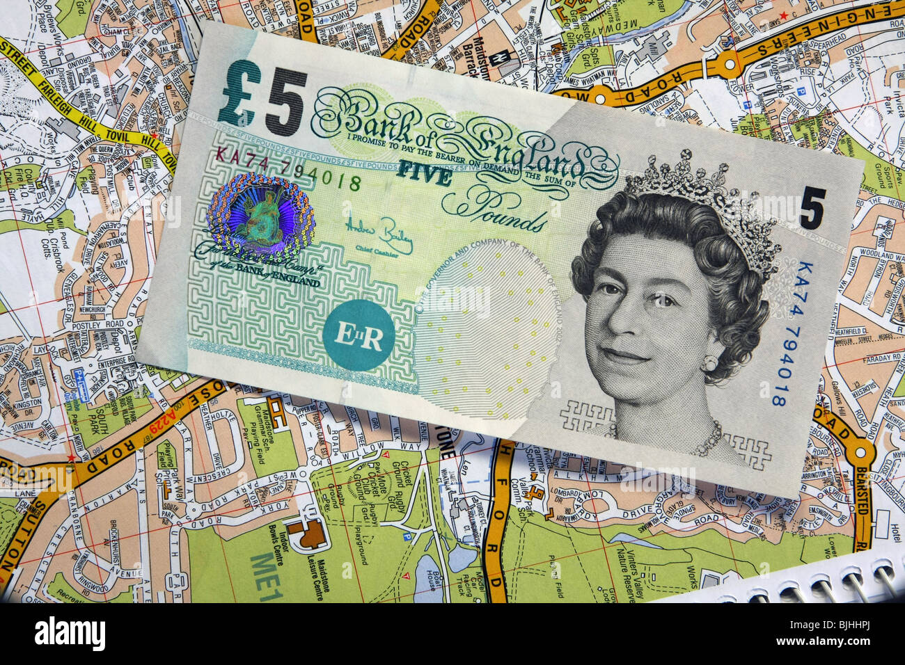 a £5 note on a the page of an open road map Stock Photo - Alamy