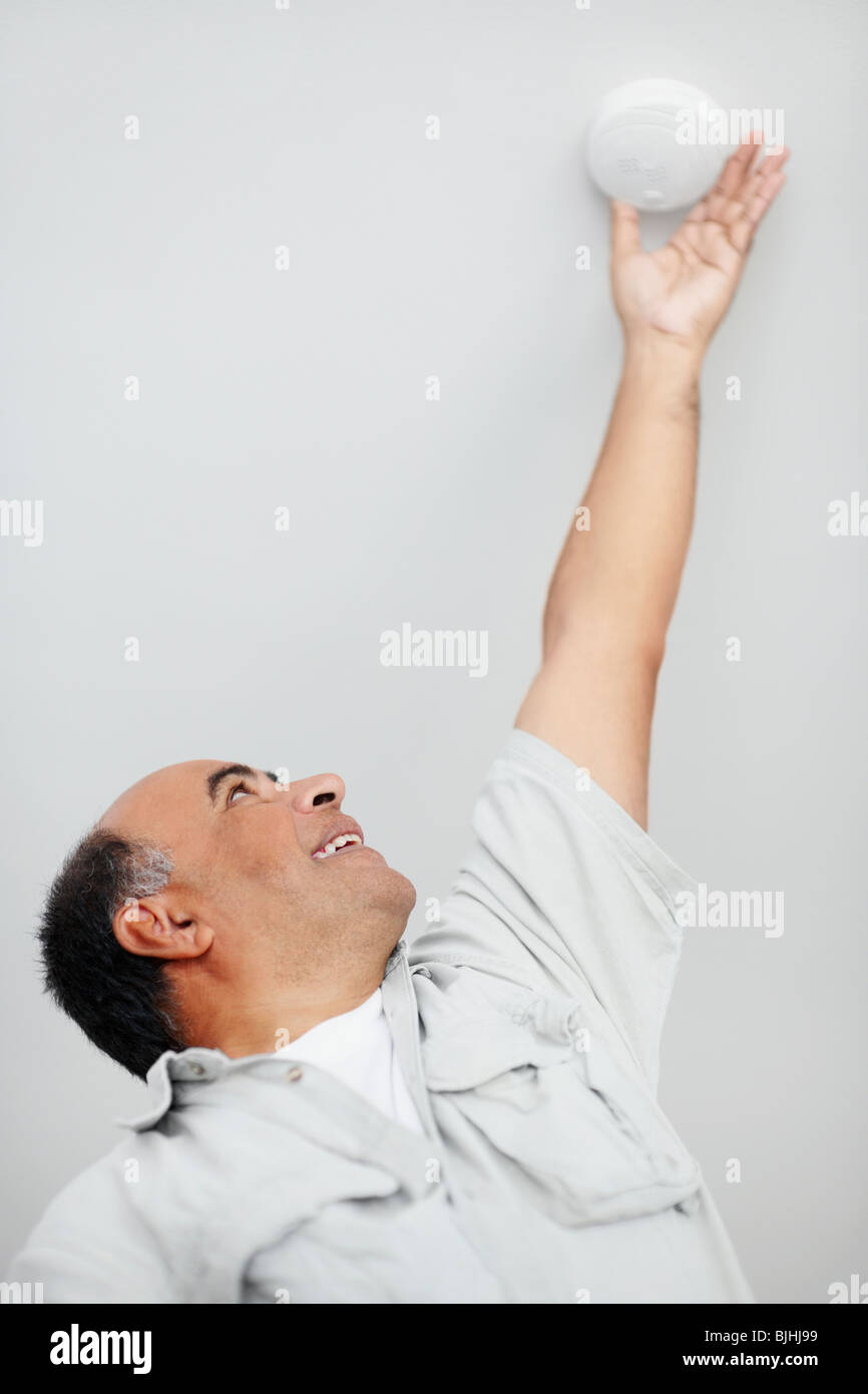 Man reaching up to smoke detector Stock Photo - Alamy