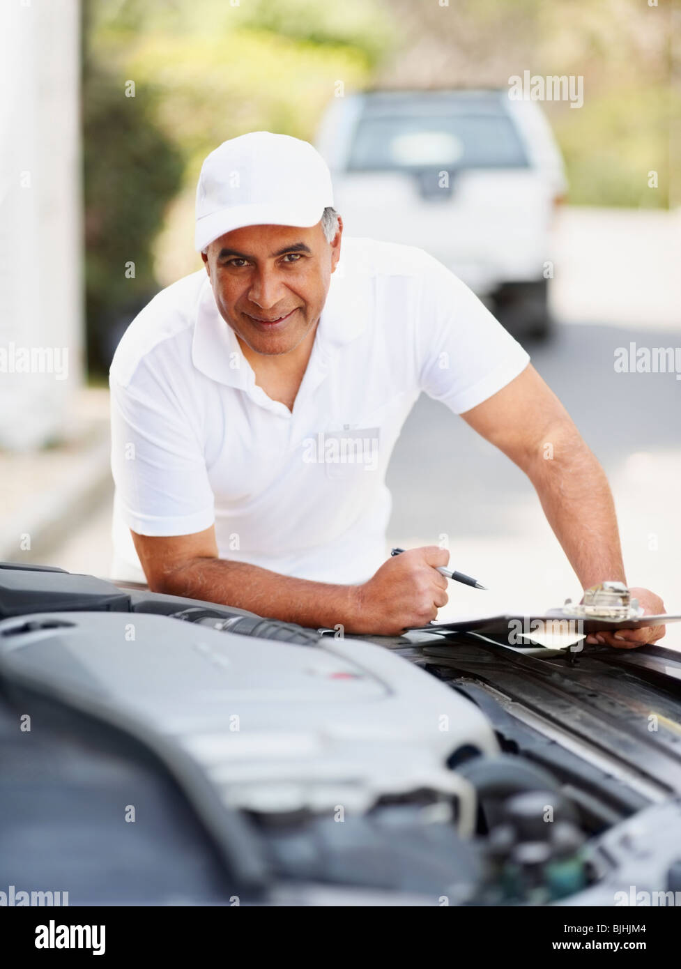 Man looking at car's engine Stock Photo - Alamy