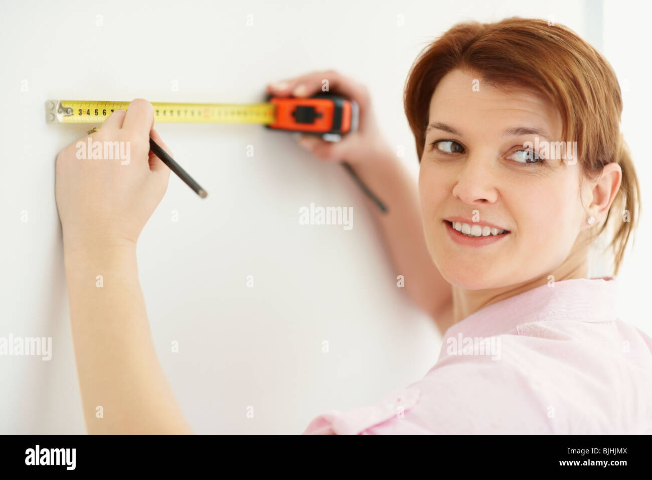 Woman using measuring tape Stock Photo - Alamy