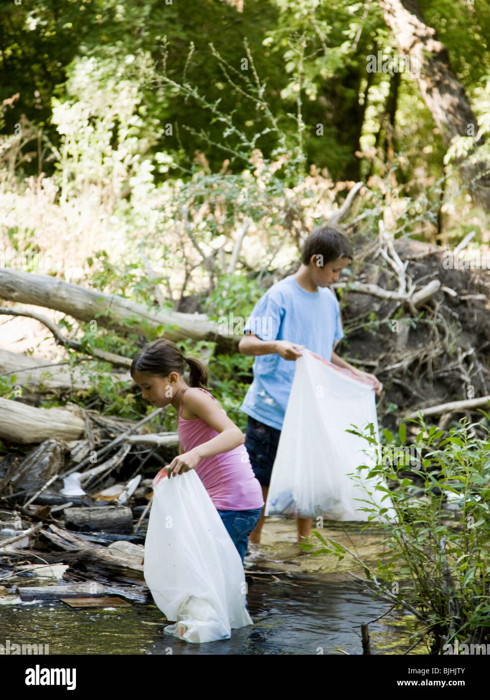 brother and sister cleaning up a river Stock Photo - Alamy