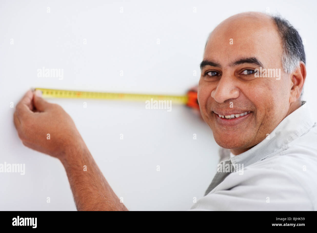 Man measuring wall Stock Photo - Alamy