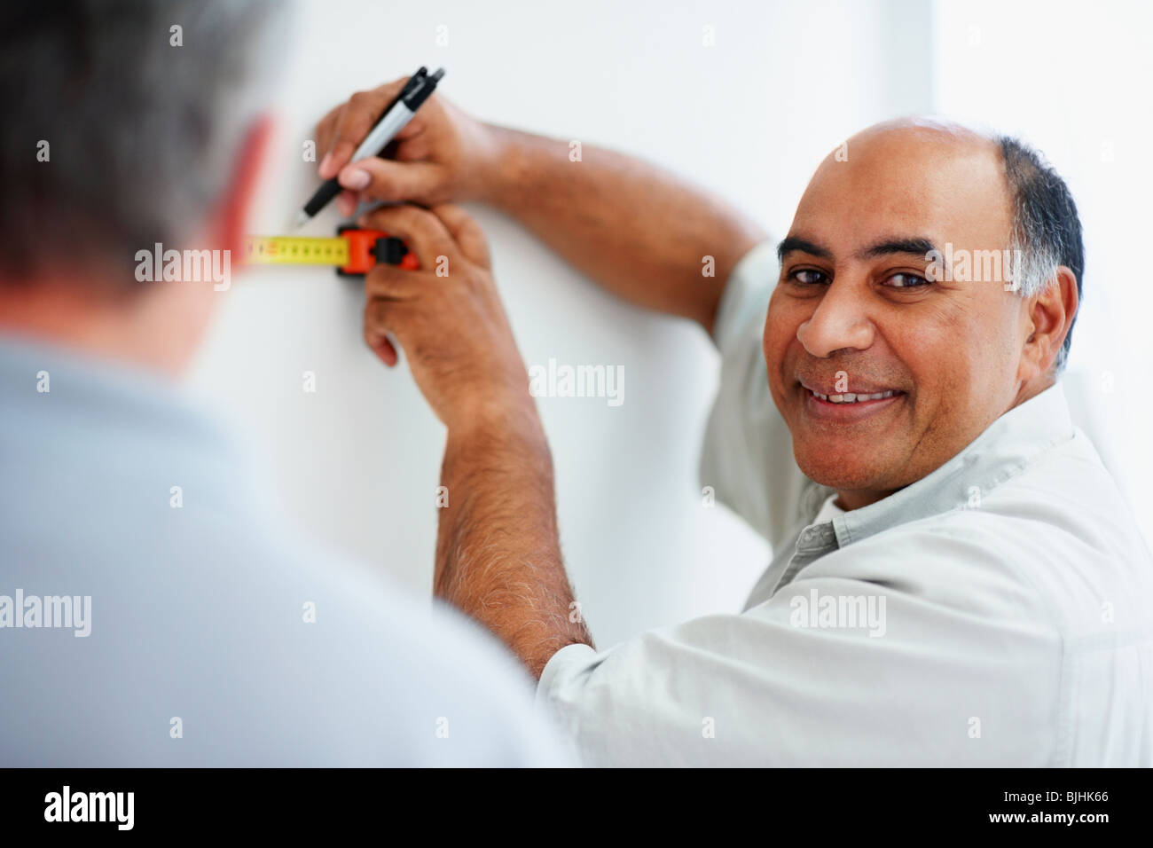 Man measuring wall Stock Photo - Alamy