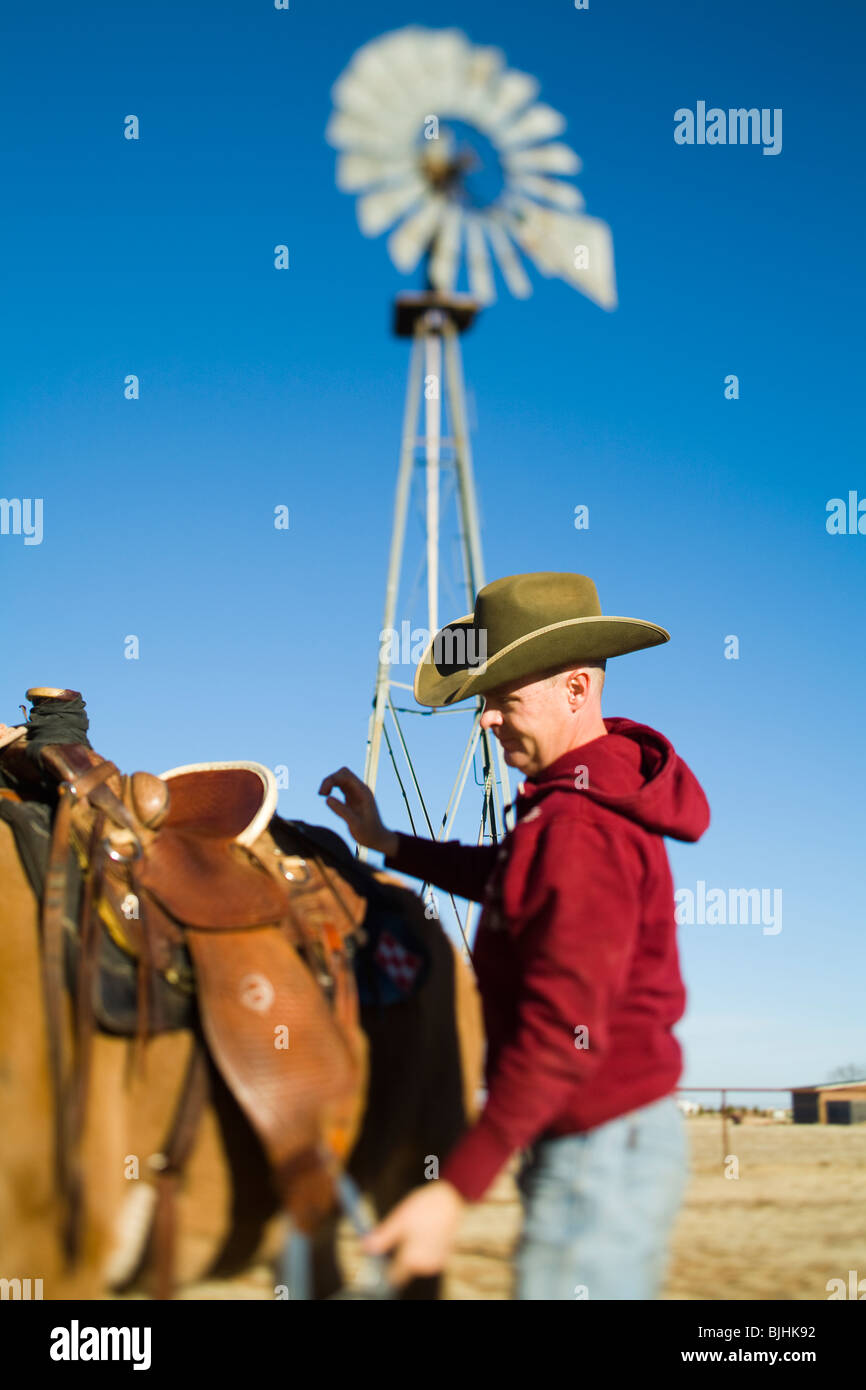 cowboy saddling up his horse Stock Photo - Alamy