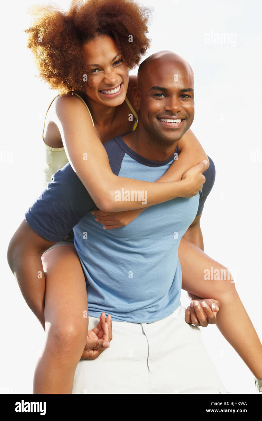 Man giving woman a piggy back ride Stock Photo - Alamy
