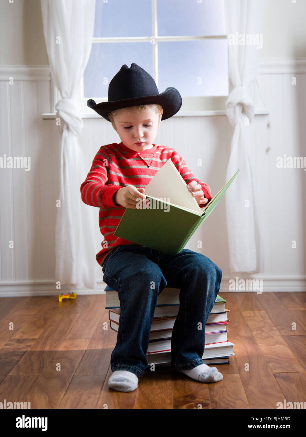 boy wearing a cowboy hat reading a book Stock Photo - Alamy