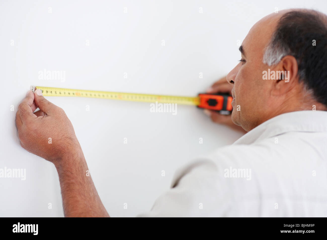 Man measuring wall Stock Photo - Alamy