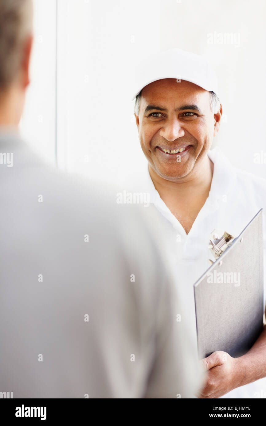 Handyman talking to customer Stock Photo - Alamy