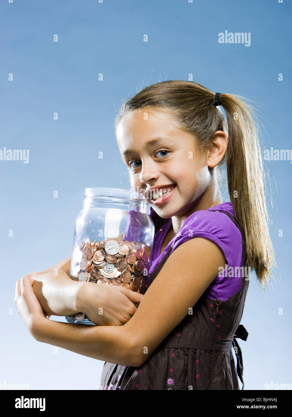 Girl holding coins jar hi-res stock photography and images - Alamy