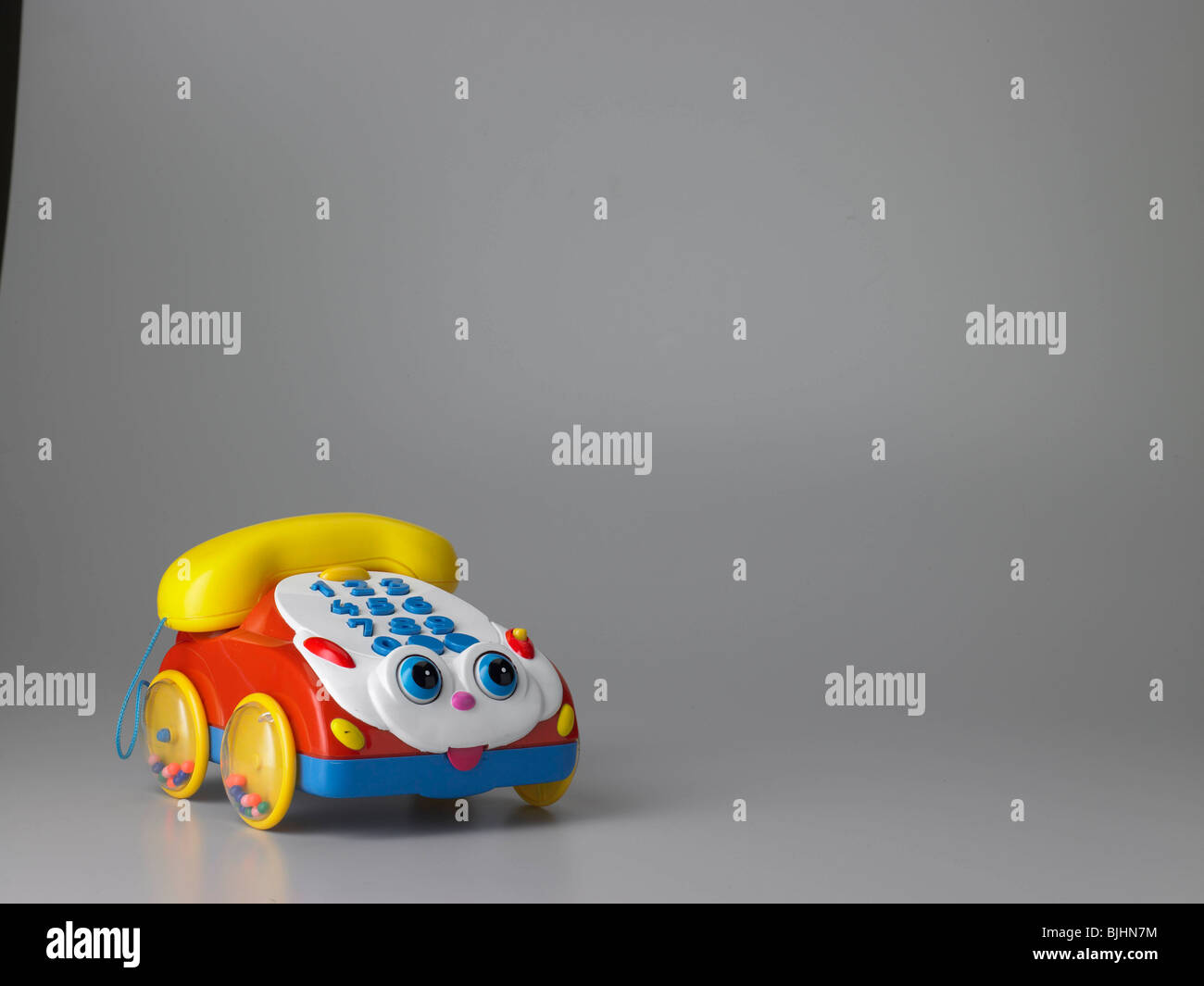 Fun toy telephone on grey Stock Photo - Alamy